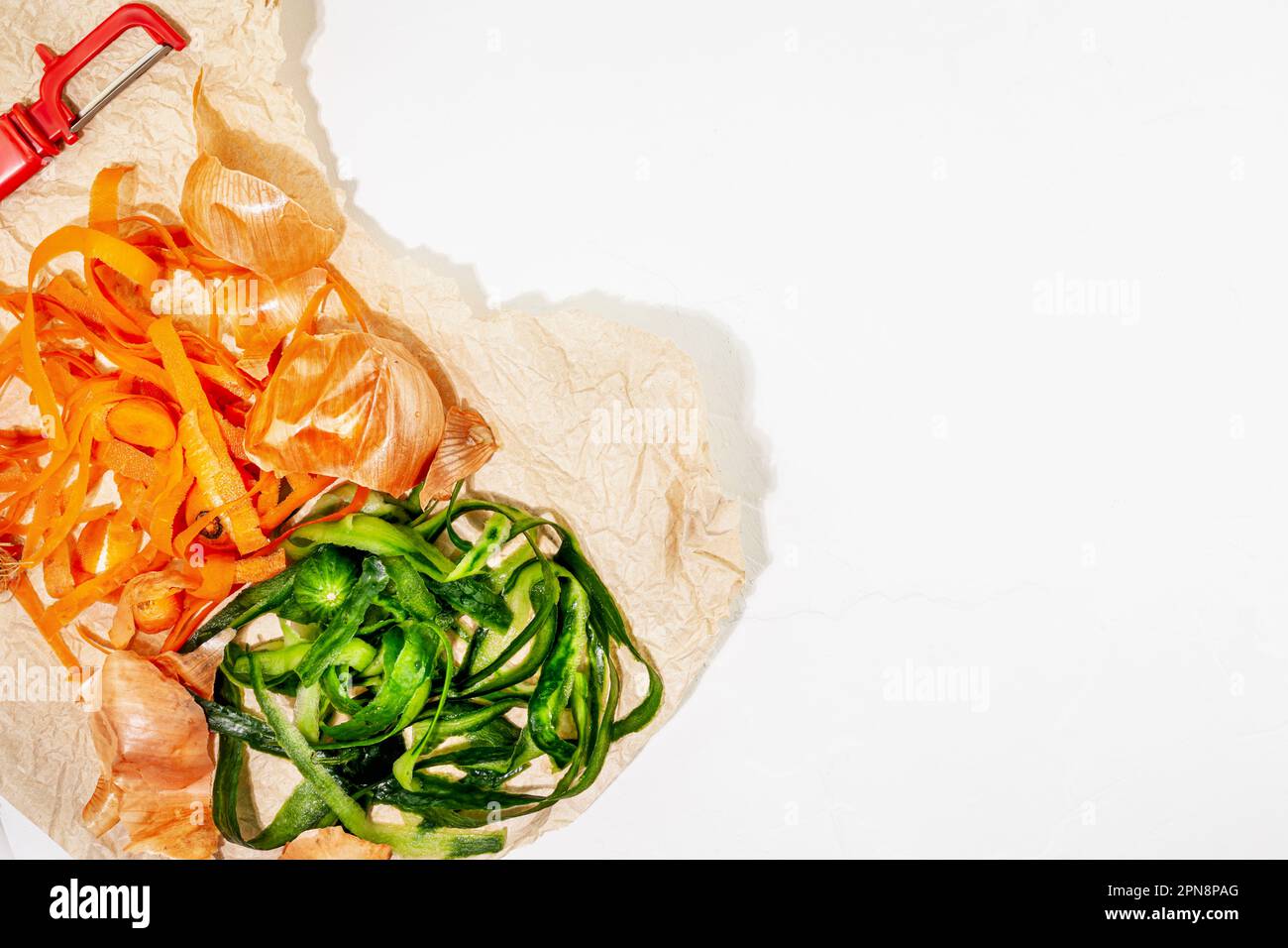 Vegetable scraps ready for composting. Vegetable peelings on paper and ...