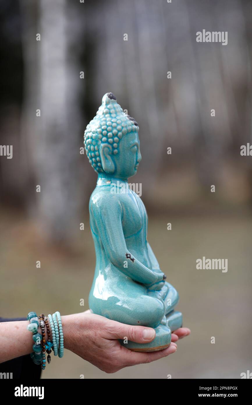 Woman with green Buddha statue in hands. France Stock Photo - Alamy