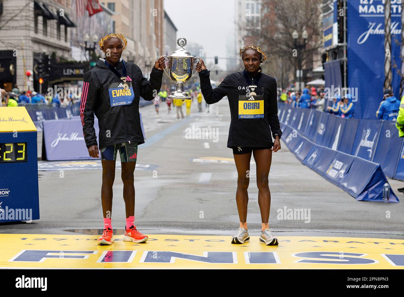 Evans Chebet and Hellen Obiri, both of Kenya, hold the trophy at the finish line after winning ...