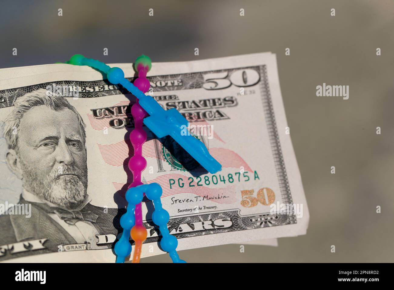 Money and religion. Banknotes of US dollars with rosary. Catholic ...