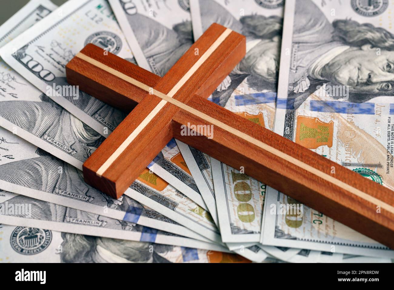 Money and religion. Banknotes of US dollars with wooden cross ...