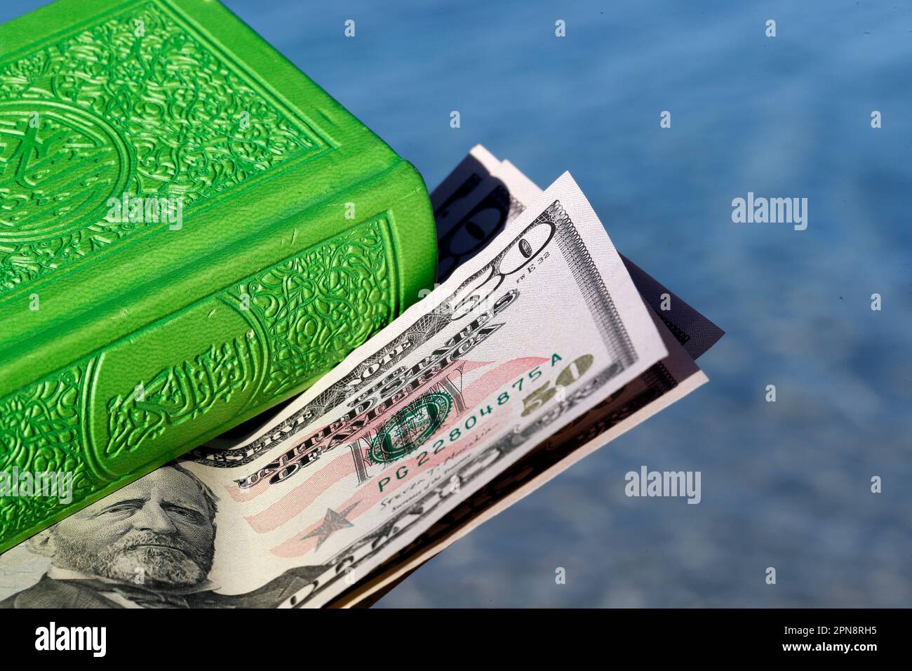 Money and religion. Banknotes of US dollars with Holy Quran book ...