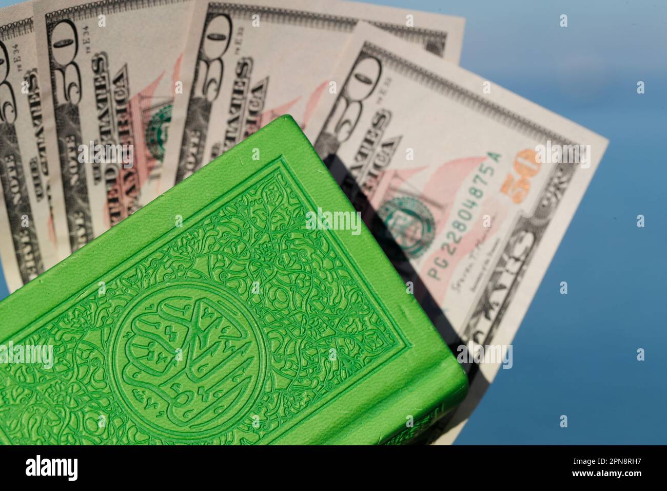 Money and religion. Banknotes of US dollars with Holy Quran book ...