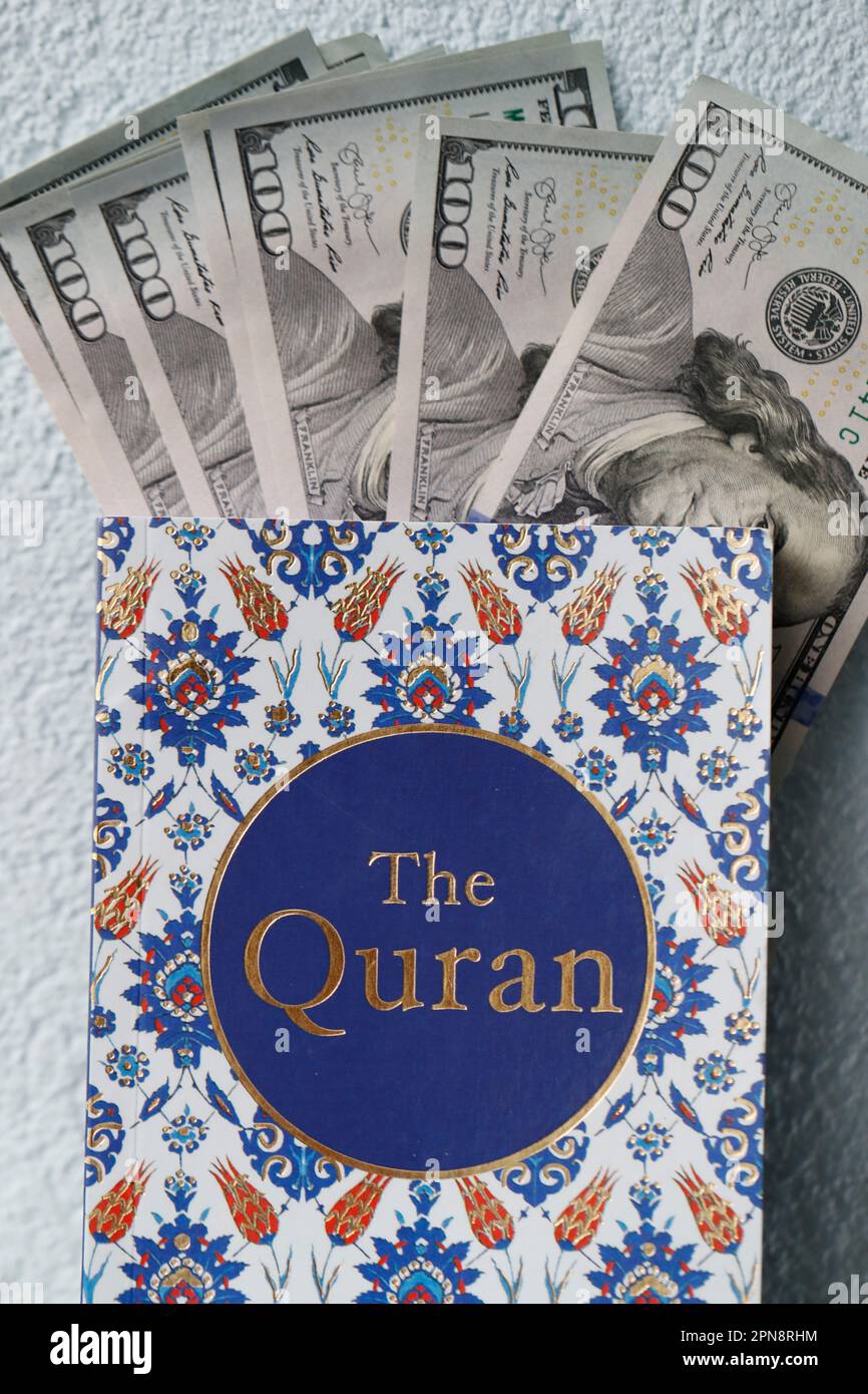 Money and religion. Banknotes of US dollars with Holy Quran book ...