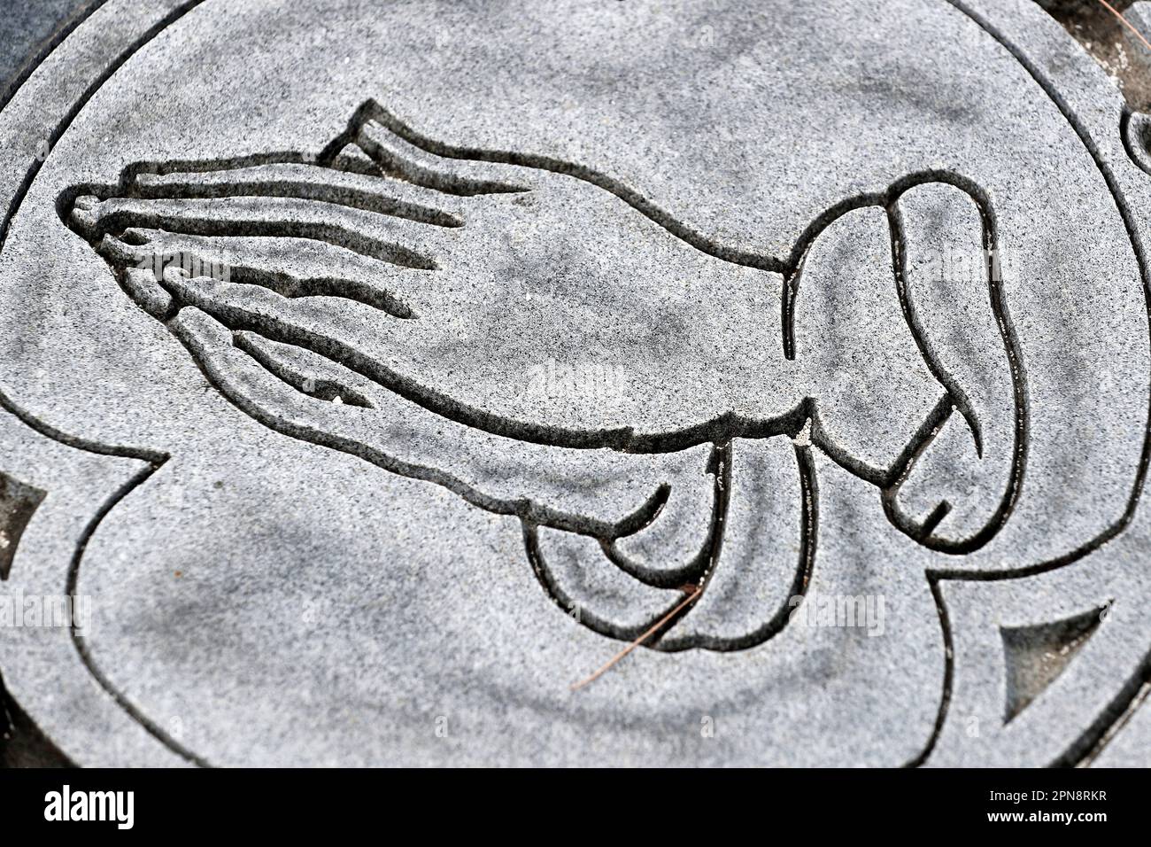 West bay cemetery. Praying hands on a tombstone Stock Photo - Alamy