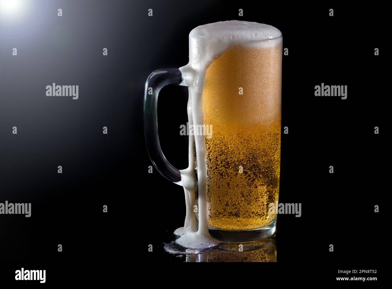 Cold beers with foam drops on dark background. Pouring foam on the ...