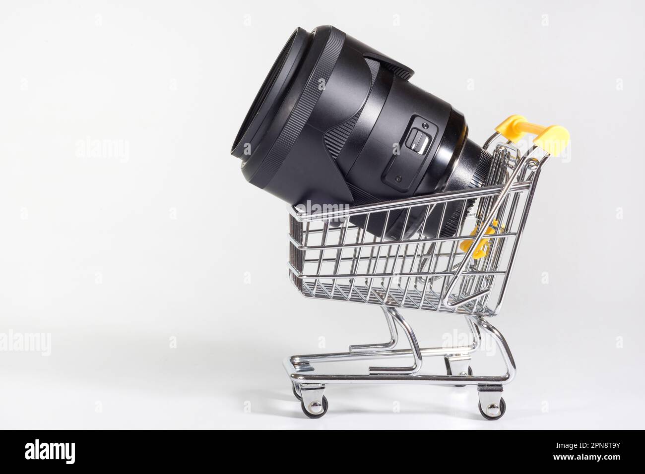 A lens in a shopping cart. Buying photo technics Stock Photo - Alamy