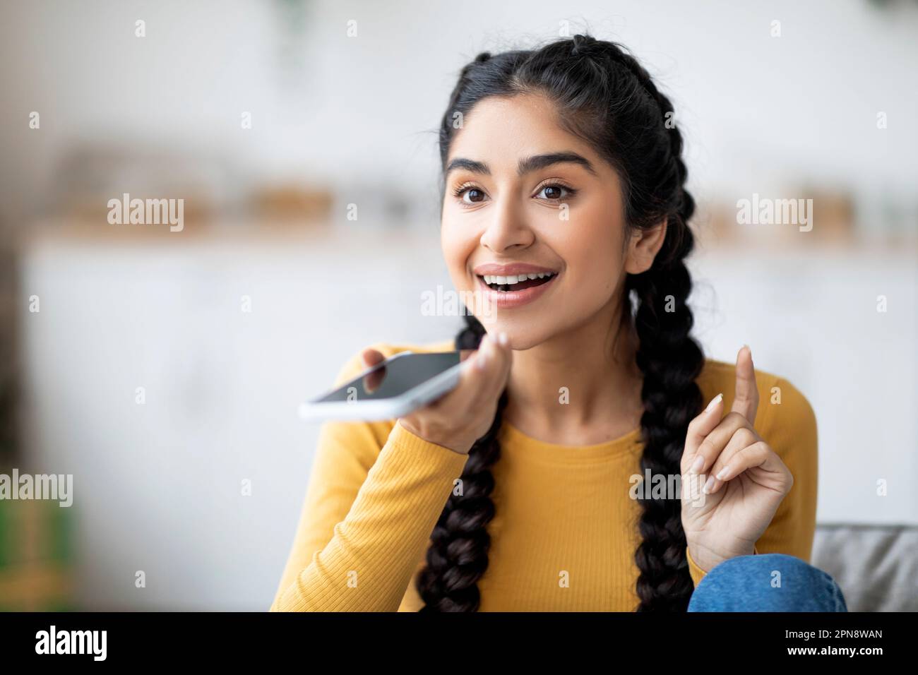 Portrait Of Smiling Young Indian Female Recording Voice Message On ...