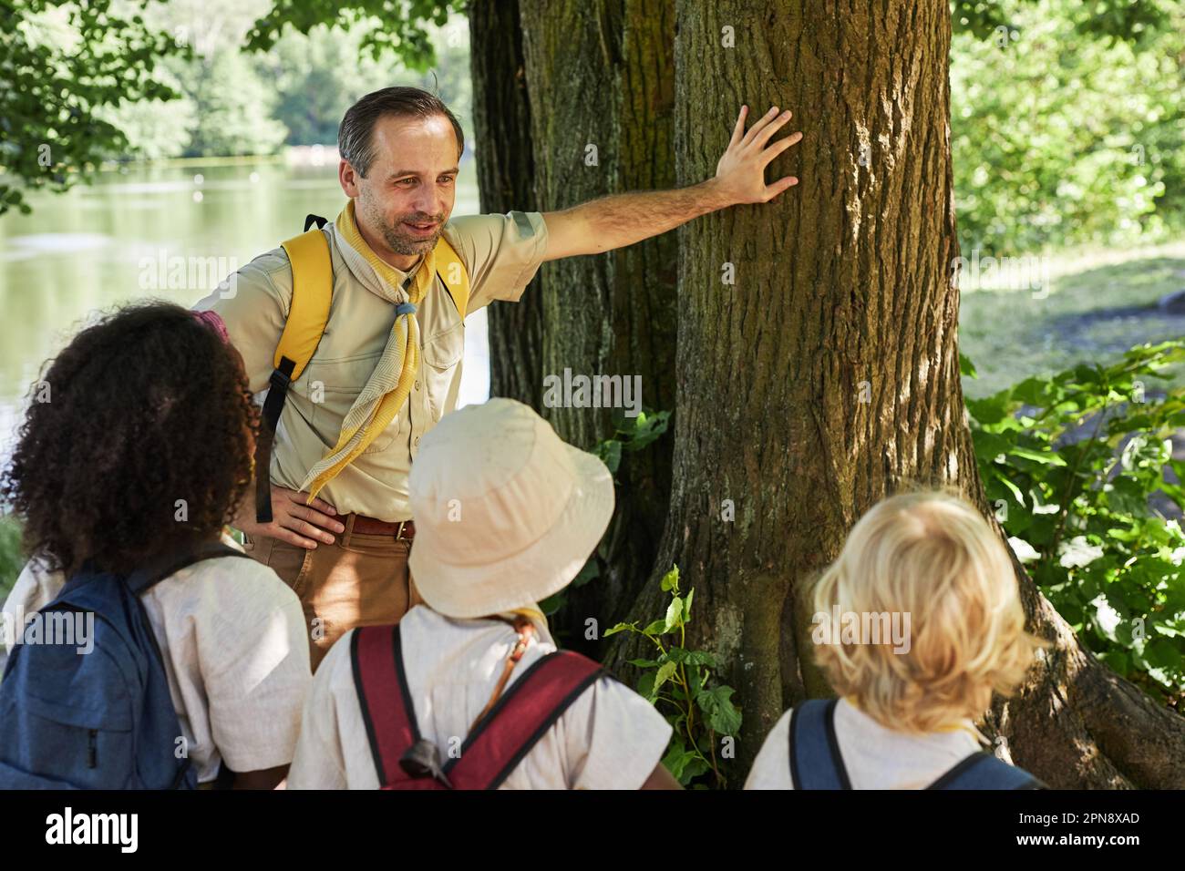 High angle portrait of smiling adult man as scout leader talking to ...