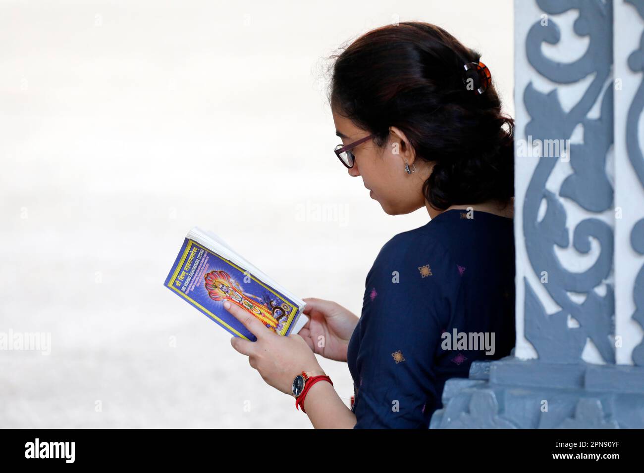 Sri Srinivasa Perumal hindu temple. Woman reading holy book. Vishnu ...