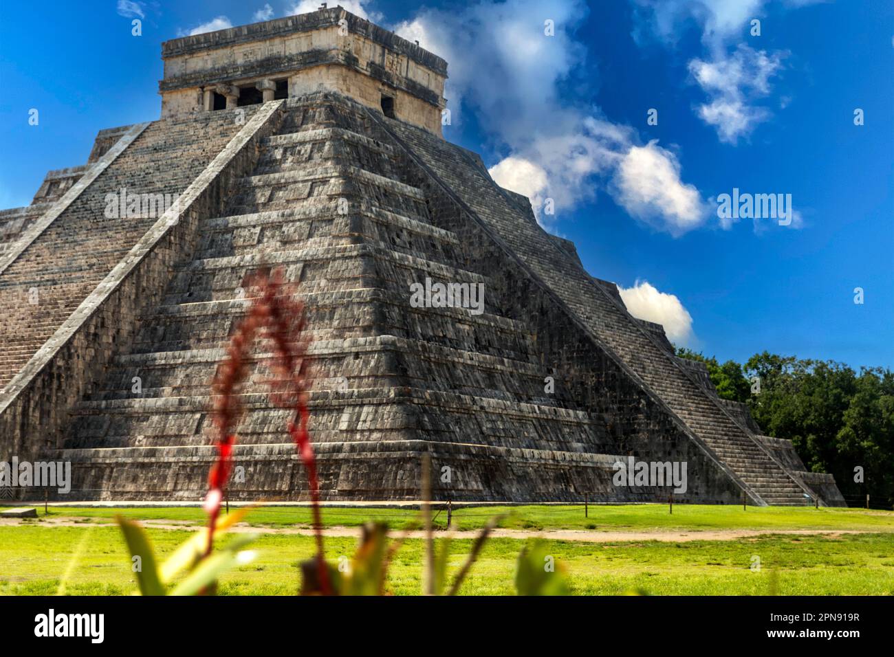 The Chichen Itza pyramid of Mexico under the blue sky is the famous ...
