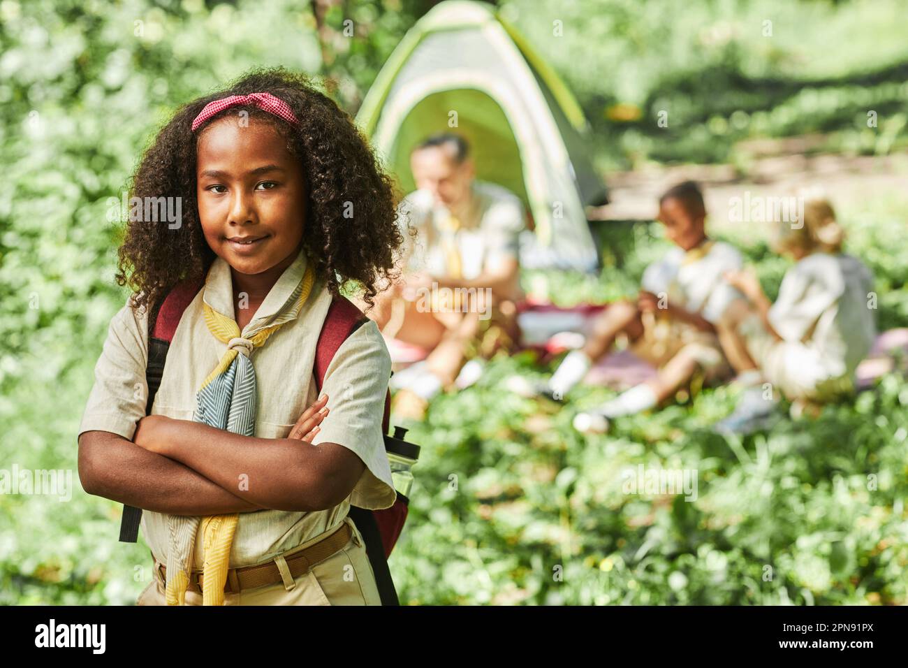 Waist up portrait of cute black girl scout looking at camera while ...