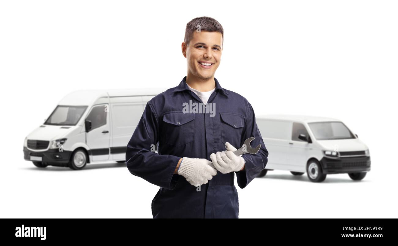 Smiling mechanic worker holding a wrench and standing in front of two ...