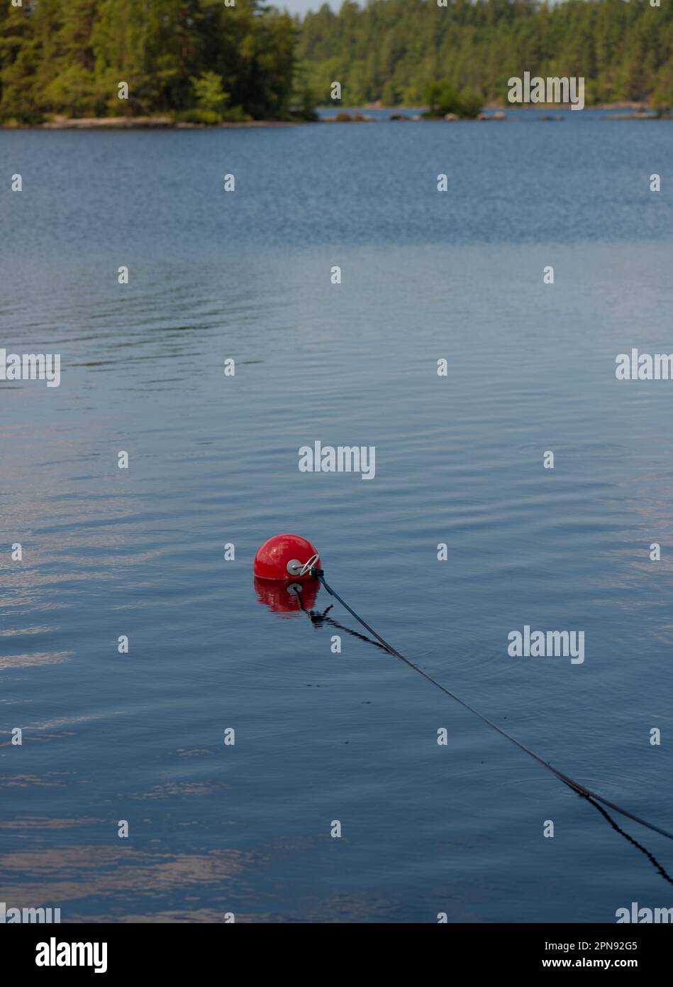 A red bouy used for mooring small boats in a lake Stock Photo - Alamy
