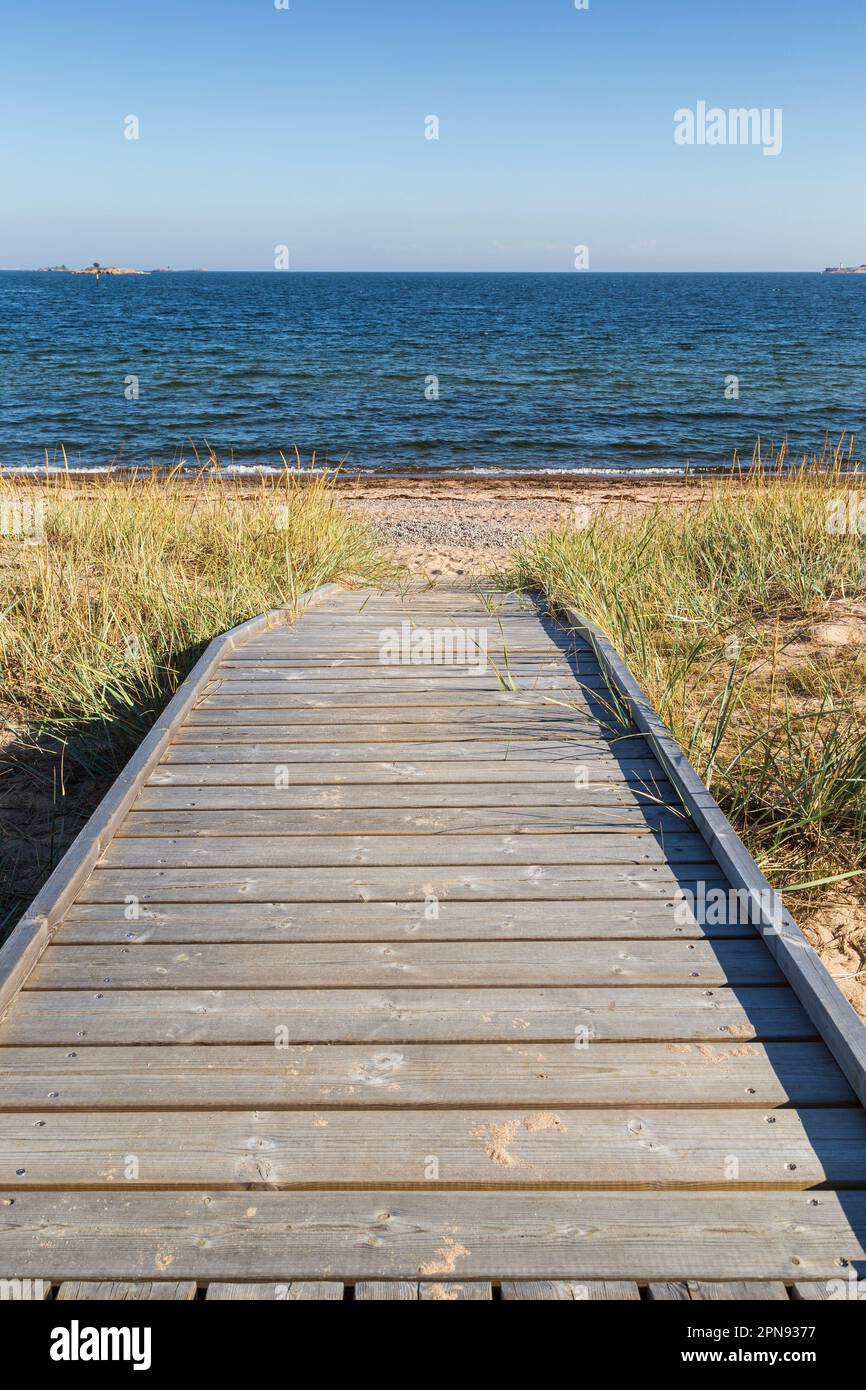 Wooden boardwalk leading to an empty beach in Hanko, Finland, on a ...