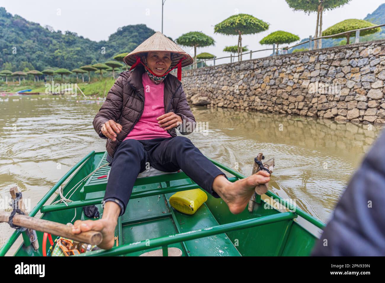 TAM COC, VIETNAM - DECEMBER 31, 2022: A Vietnamese woman rows a boat ...