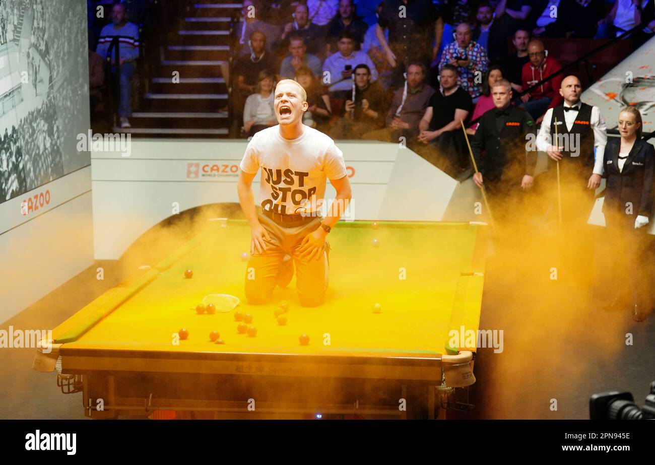 A Just Stop Oil protester jumps on the table and throws orange powder ...
