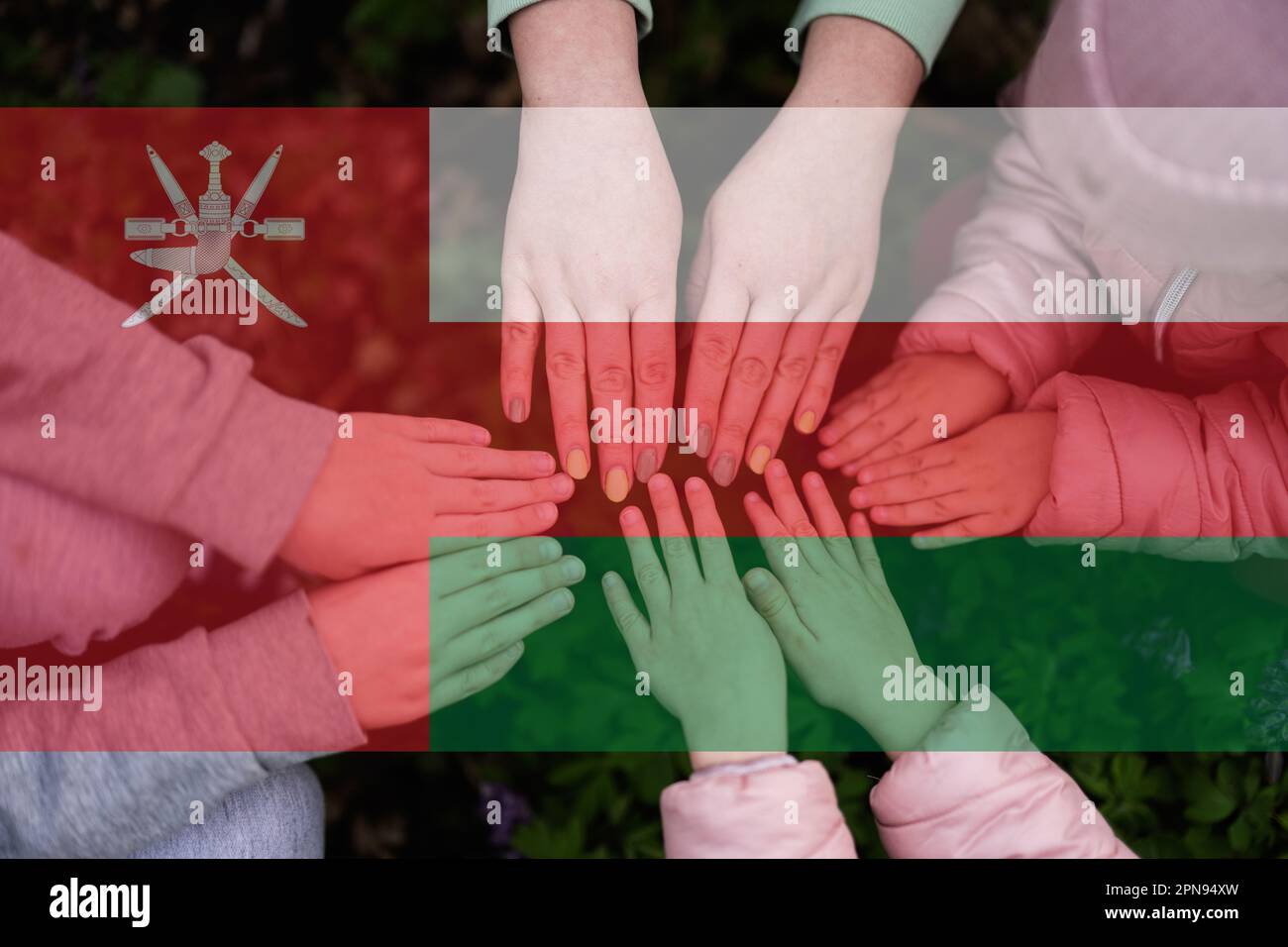 Hands of kids on background of Oman flag. Omani patriotism and unity ...