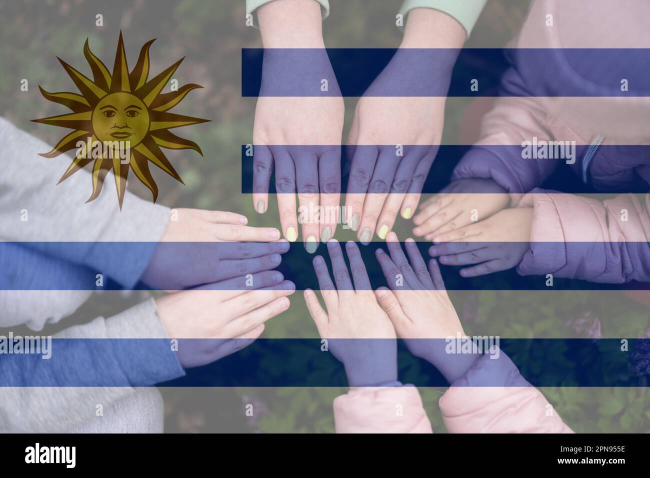 Hands of kids on background of Uruguay flag. Uruguayan patriotism and ...