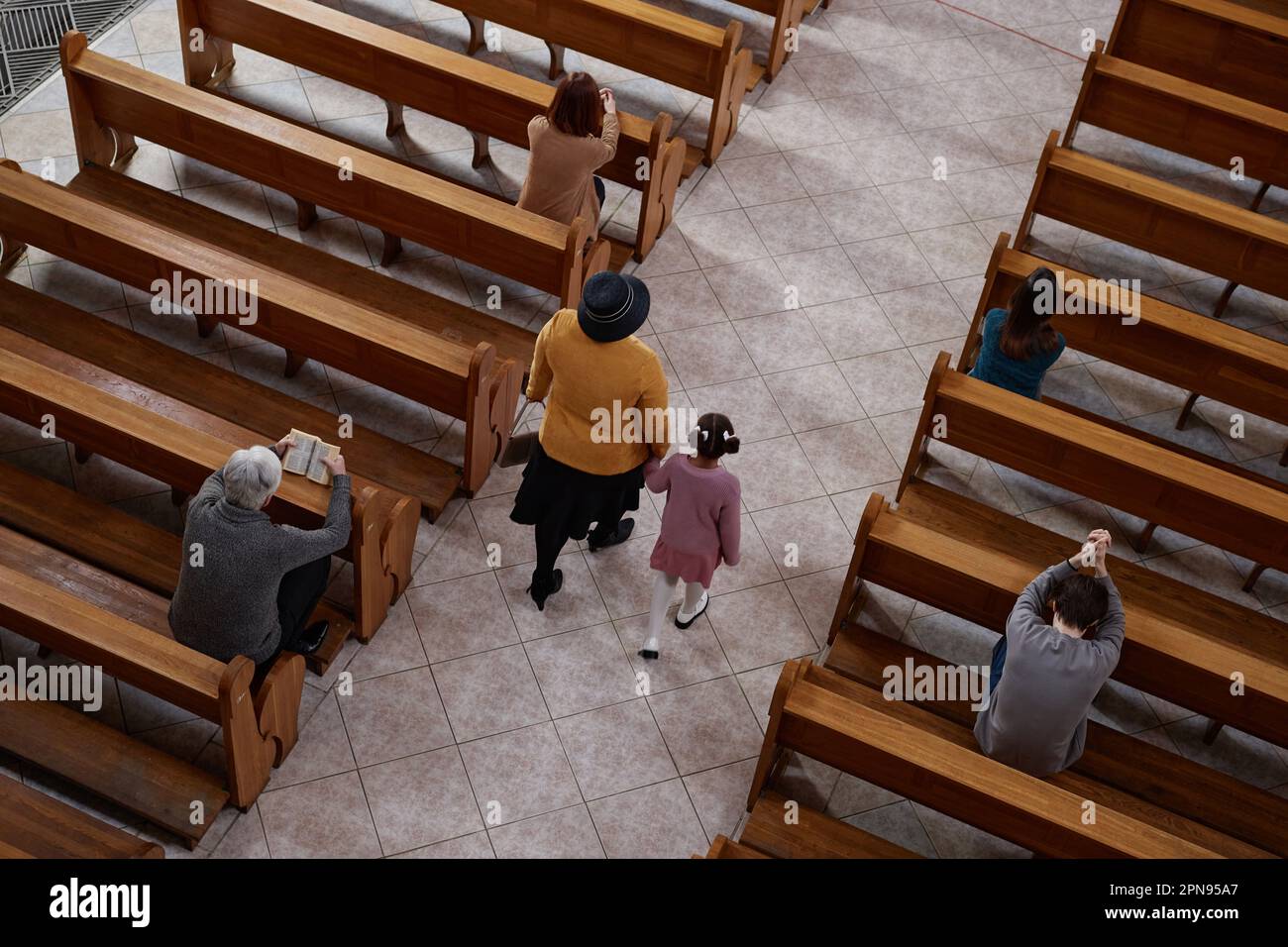 High angle view of believer people praying while sitting on benches in ...