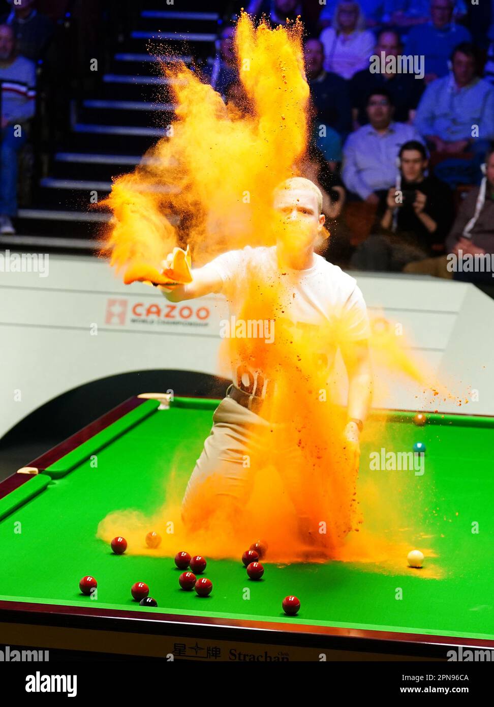 A Just Stop Oil protester jumps on the table and throws orange powder ...