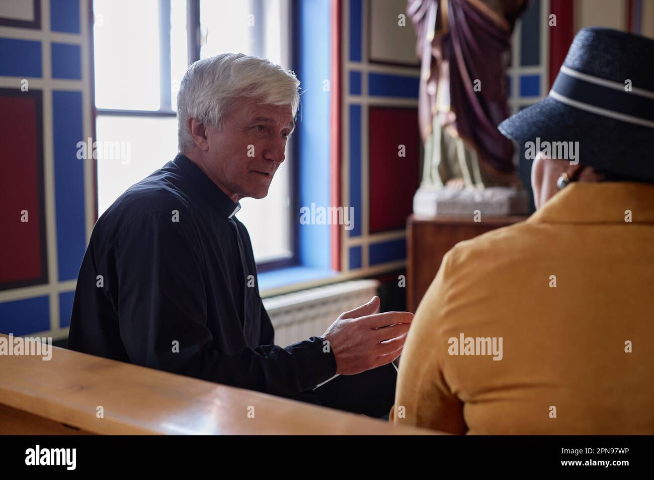 Senior priest discussing christian moments with woman while they ...