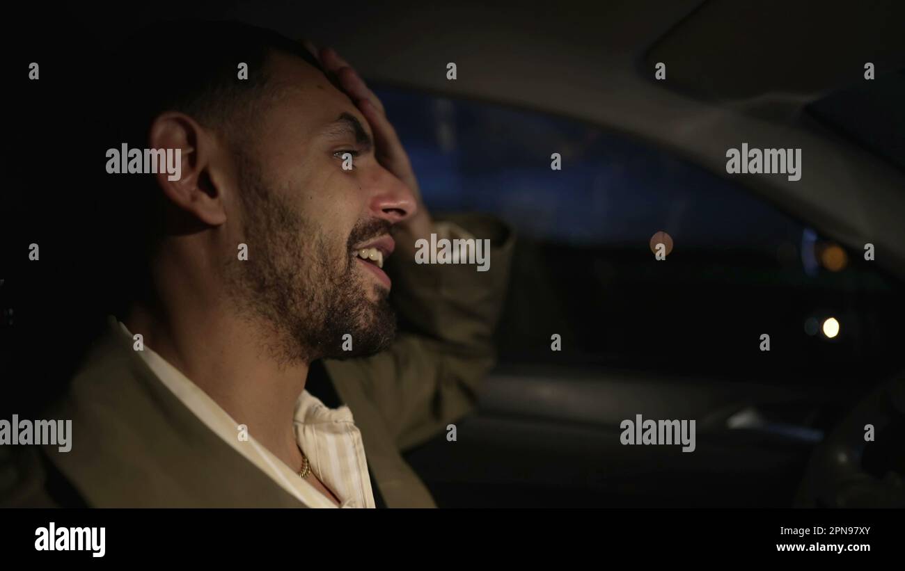 Profile of a Middle Eastern person driving at night on road. Pensive ...