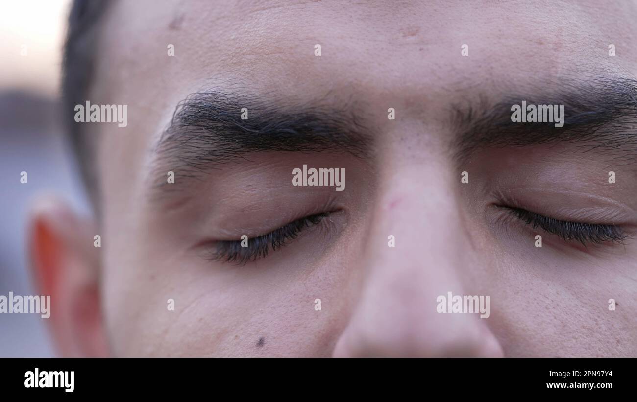 Person from Middle Eastern descent closing eyes in meditation. One ...
