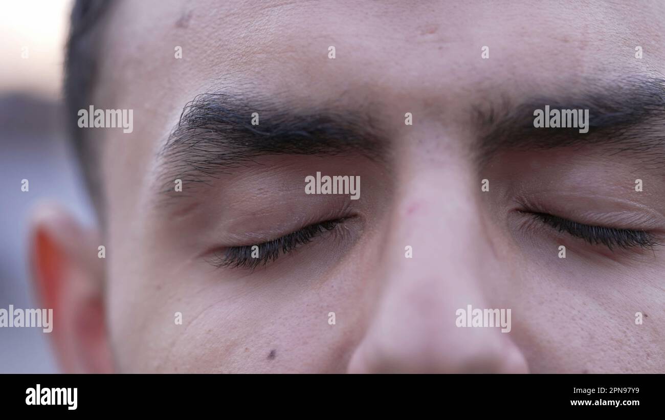Person from Middle Eastern descent closing eyes in meditation. One ...