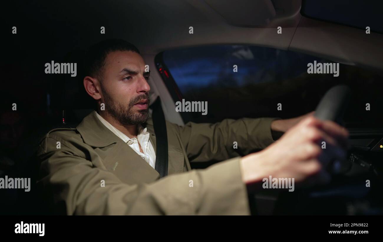 Man driving at night in anxiety. Nervous pensive Middle Eastern male ...