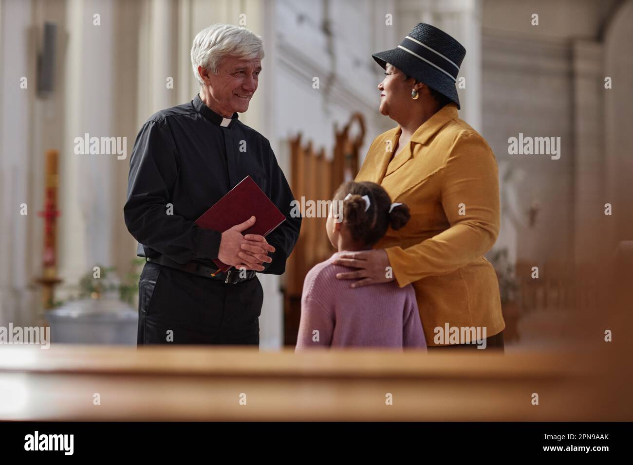 Senior priest discussing ceremony together with woman and her ...