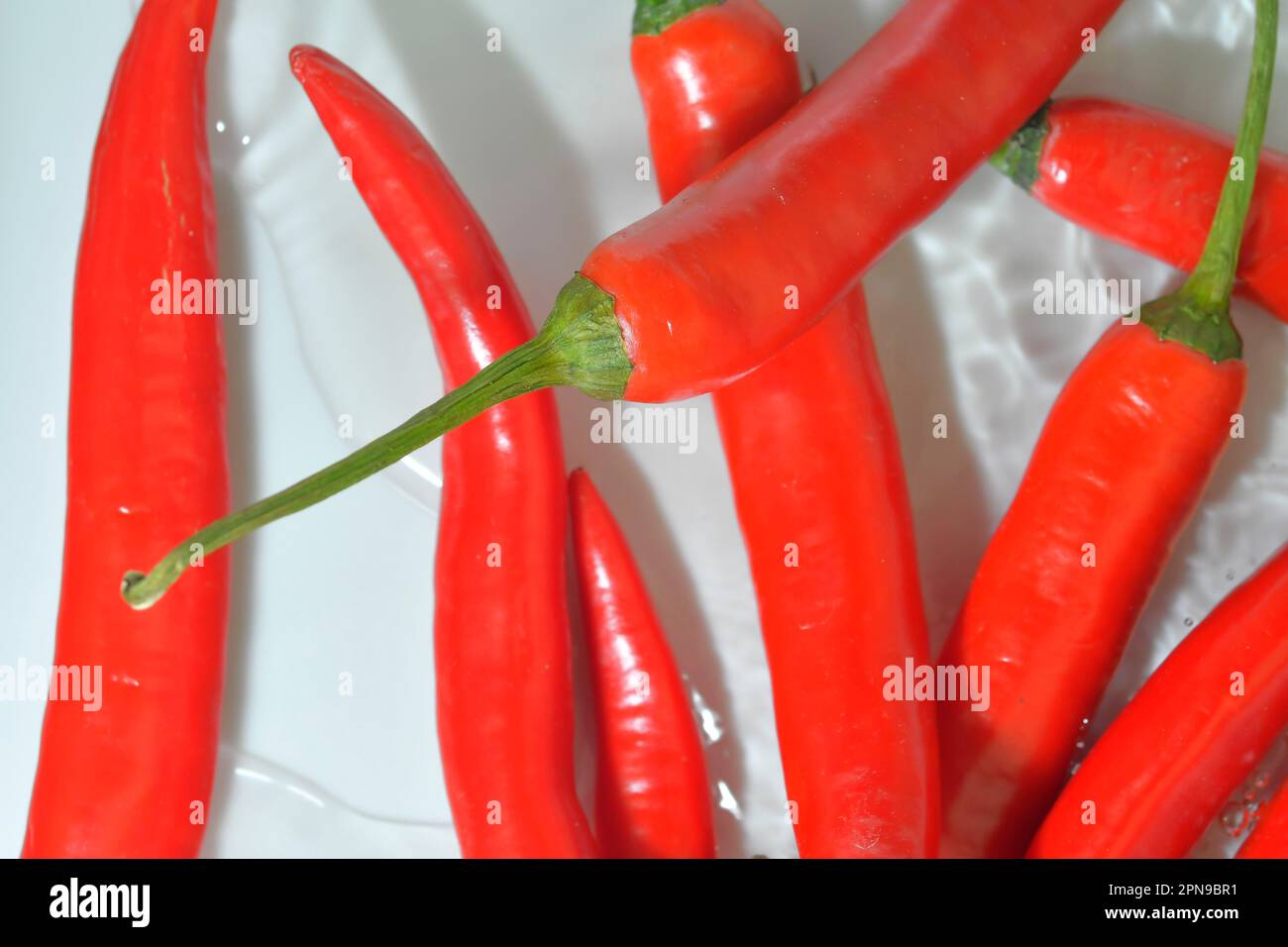 Close-up of fresh slices chilli peppers on white background. Red chilli ...