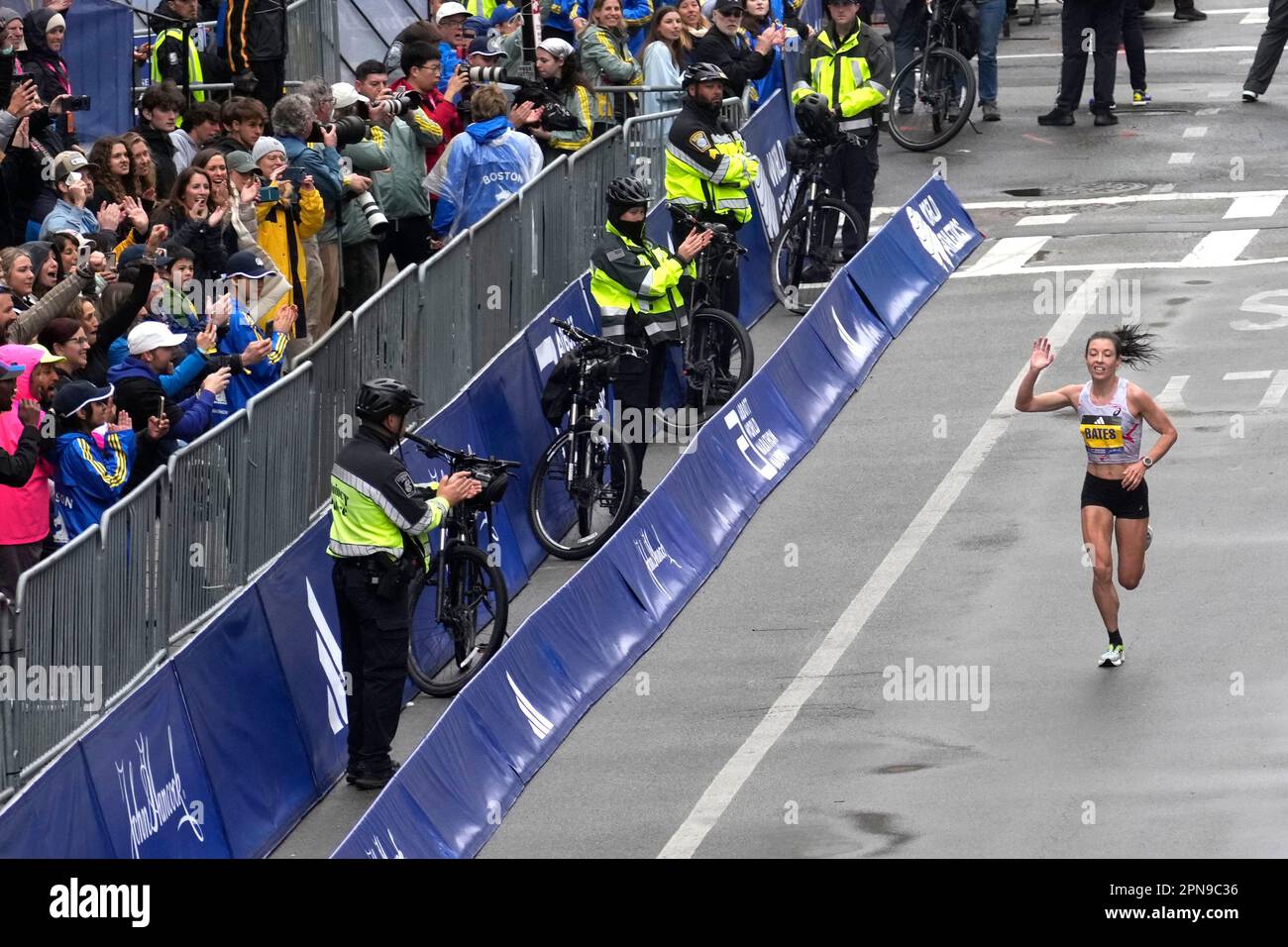 Emma Bates, of Minnesota, waves while approaching the finish line of ...