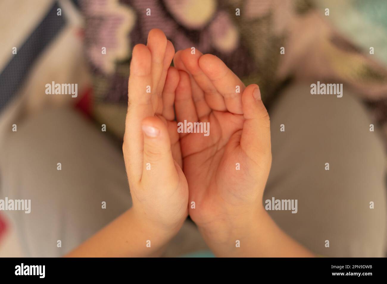 children's outstretched hands on a blurry background close-up asking ...