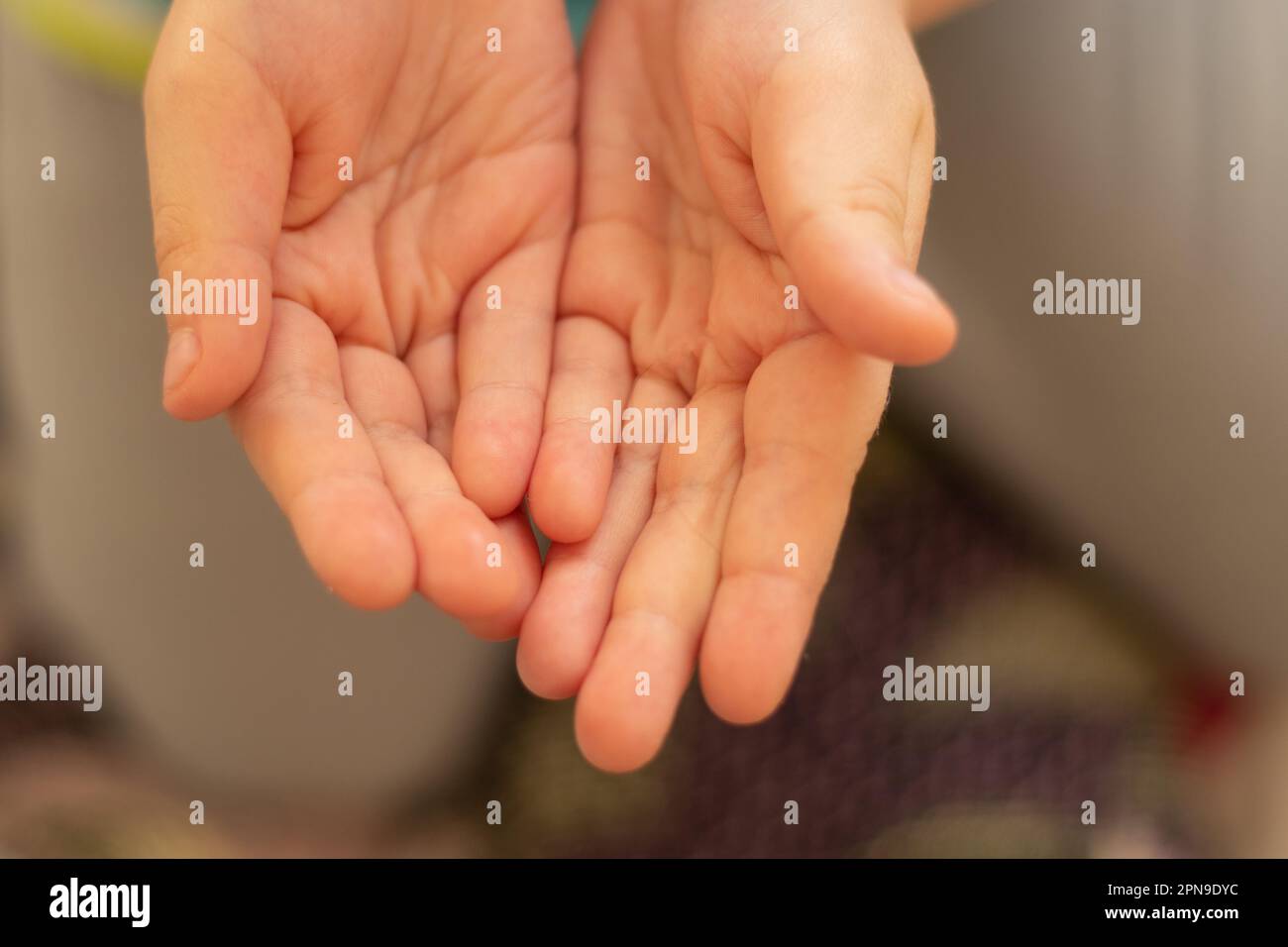 children's outstretched hands on a blurry background close-up asking ...