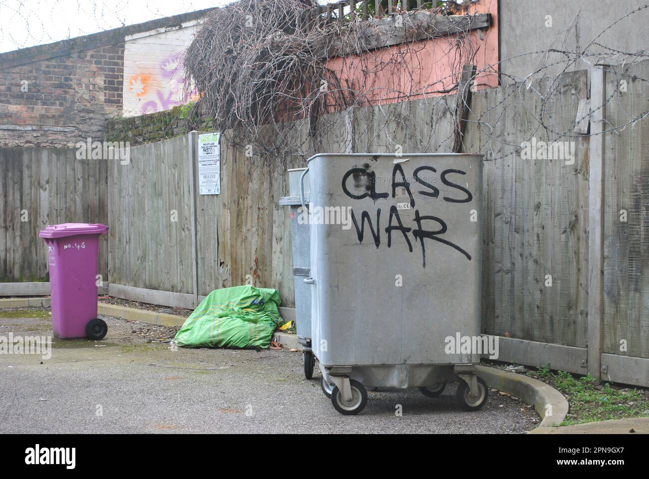 A dumpster with the words class war written on it can be seen behind ...