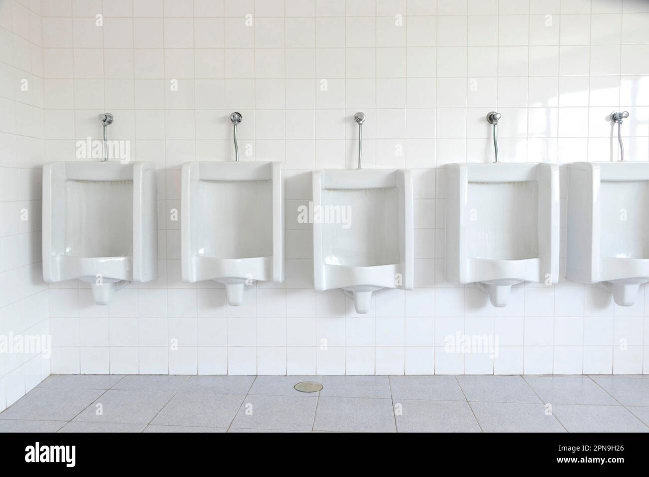 Row of white porcelain urinals and tiles in a toilet in Portugal Stock ...