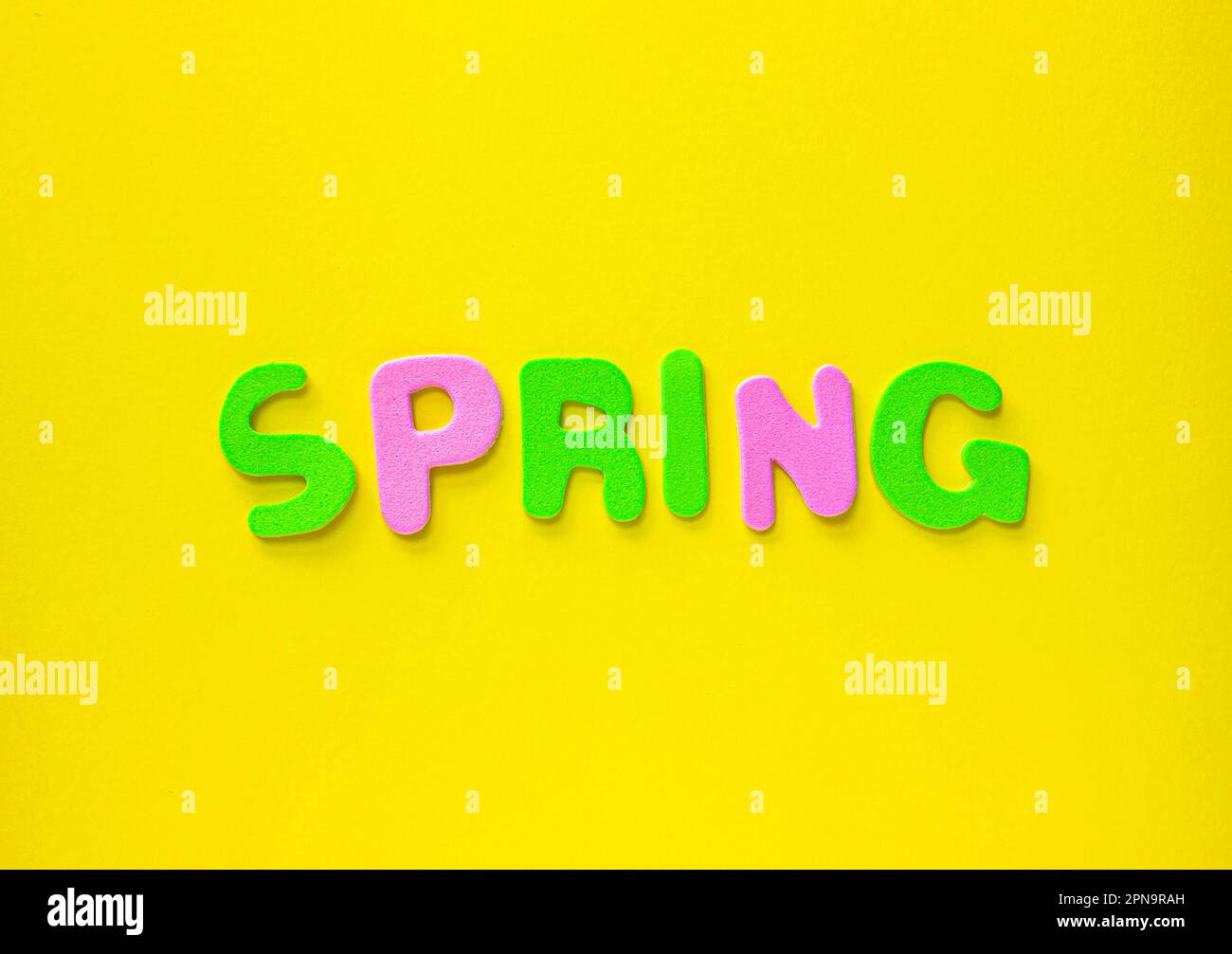 Colored letters spelling out spring on Yellow background with copy ...