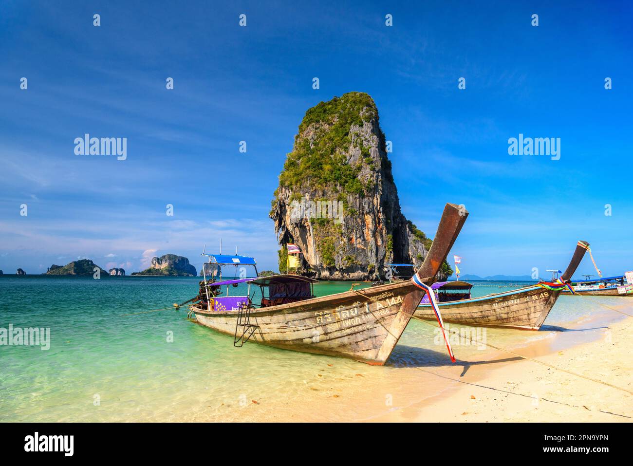 KRABI, THAILAND- MARCH 2018: Long tail boats and cliff rock in azure ...
