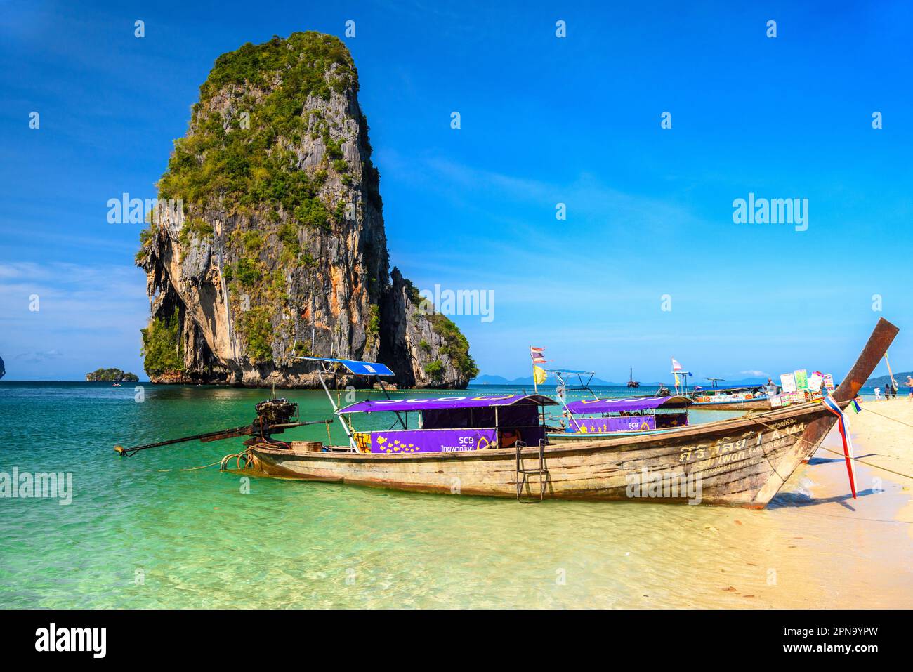 KRABI, THAILAND- MARCH 2018: Long tail boats and cliff rock in azure ...