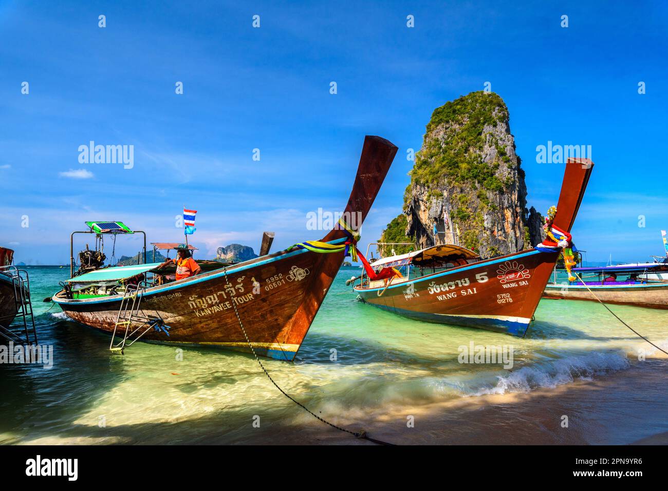 KRABI, THAILAND- MARCH 2018: Long tail boats and cliff rock in azure ...