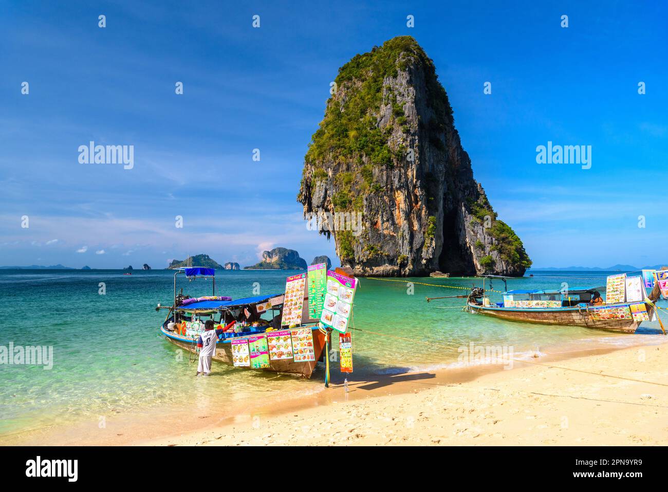 KRABI, THAILAND- MARCH 2018: Long tail boats and cliff rock in azure ...