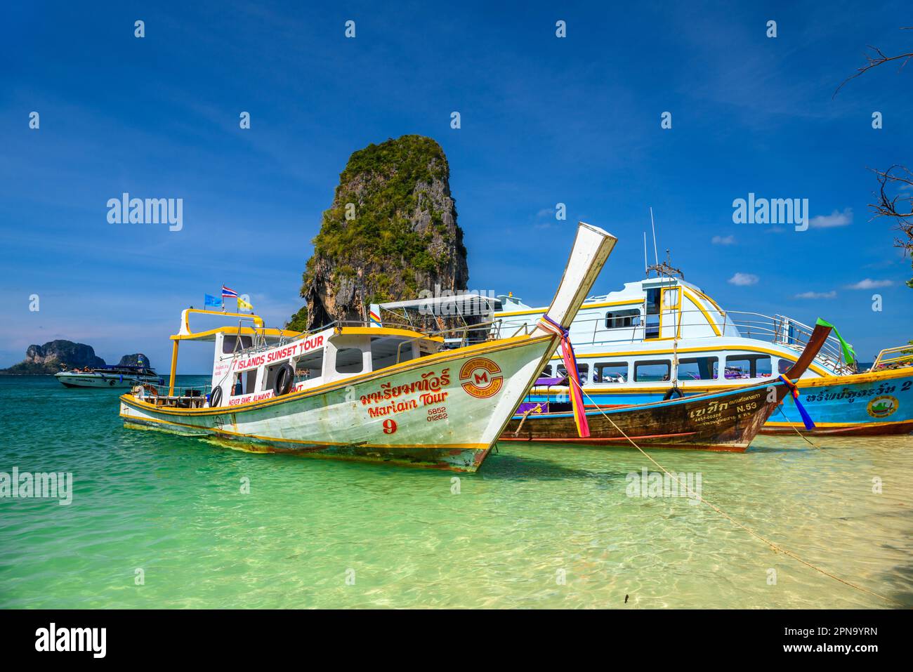 KRABI, THAILAND- MARCH 2018: Long tail boats and cliff rock in azure ...