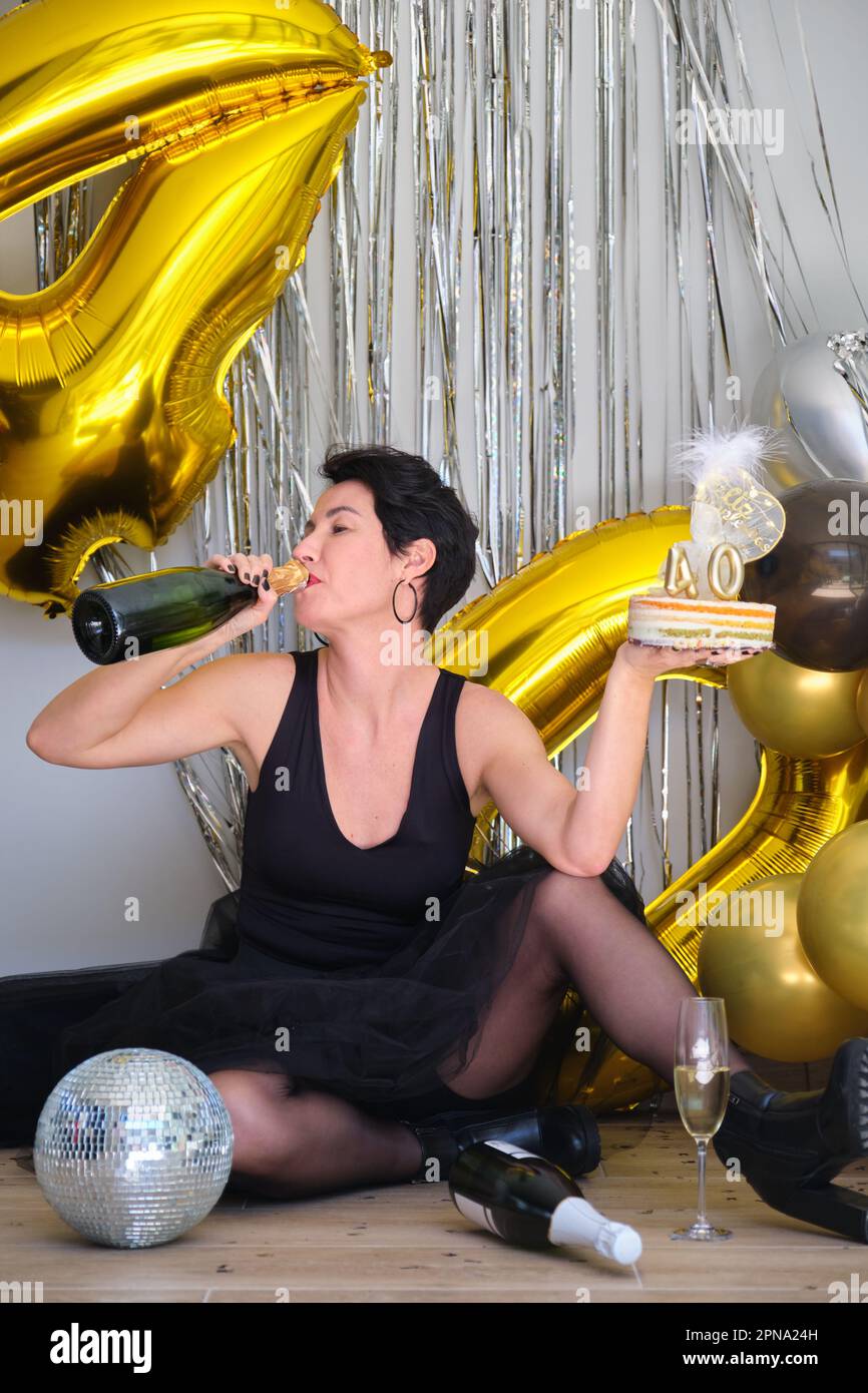 Caucasian woman drinking champagne from bottle celebrating her 40 ...