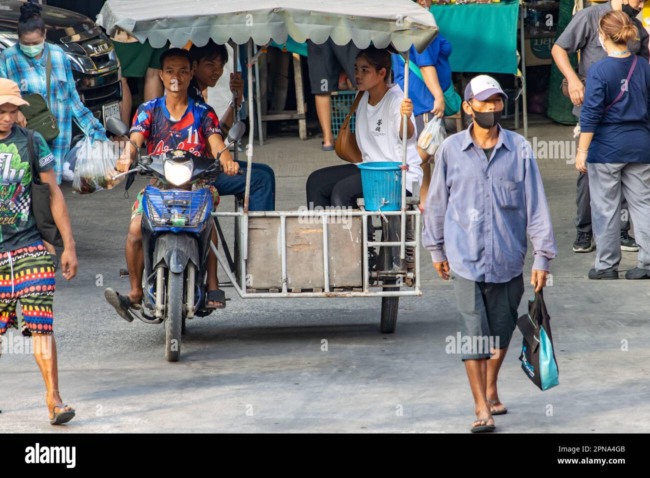 SAMUT PRAKAN, THAILAND, APR 07 2023, People ride a motorcycle with a ...
