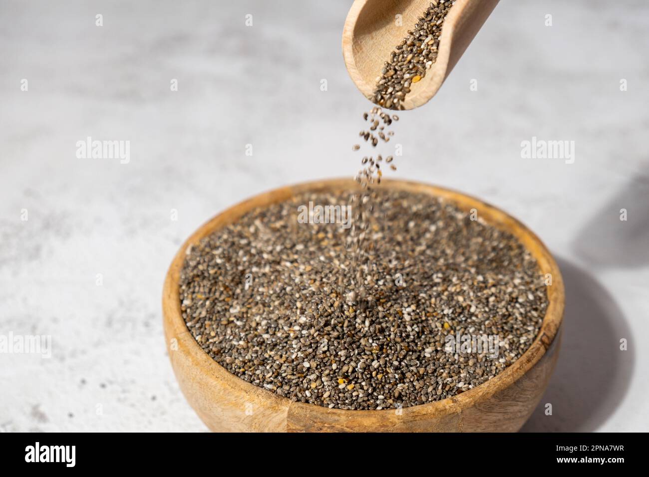 Chia seeds fall in wooden bowl. Healthy superfood rich in Omega 3 fatty ...