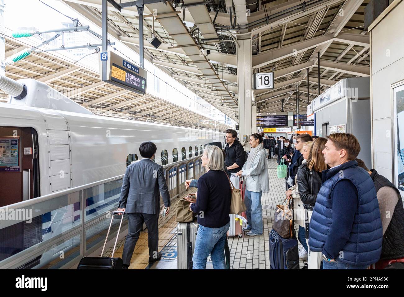 April 2023, passengers wait to board the green carriage car 8 of the bullet train Shinkansen at ...