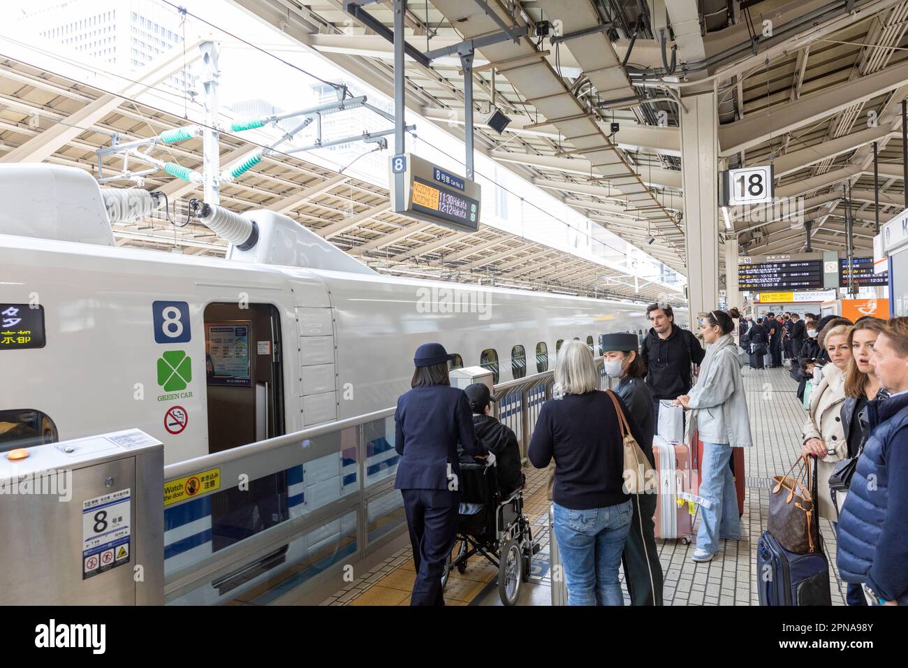 April 2023, passengers wait to board the green carriage car 8 of the bullet train Shinkansen at ...