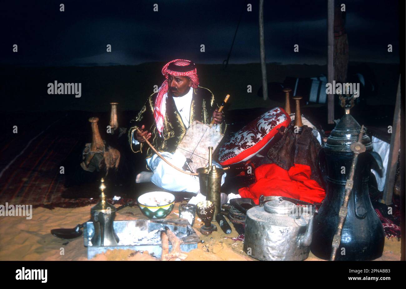 Scene in a traditional tent with Arab man playing a rababa, Saudi ...