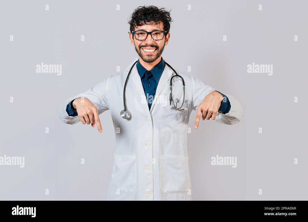 Young Doctor Pointing A Promotion Down Handsome Doctor Pointing Down An Isolated Advertising